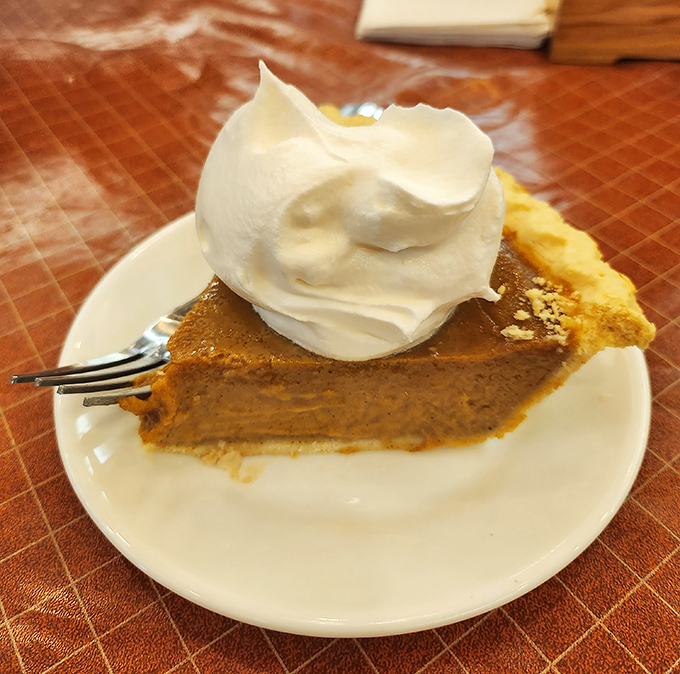 Pumpkin pie so authentic it makes store-bought versions hang their heads in shame, crowned with a dollop of whipped cream that's practically mandatory.