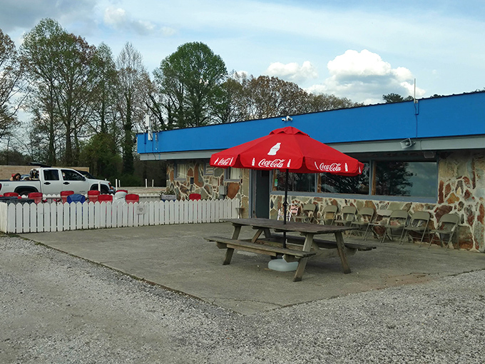 The concession stand, with its stone facade and Coca-Cola umbrella, serves as the beating heart of the drive-in experience&mdash;fueling both nostalgia and hunger.