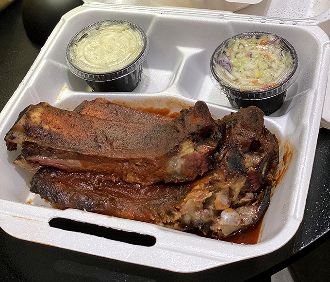These ribs don't need a fancy plate – they're confident enough to arrive in a takeout container with sides that know not to upstage the star.