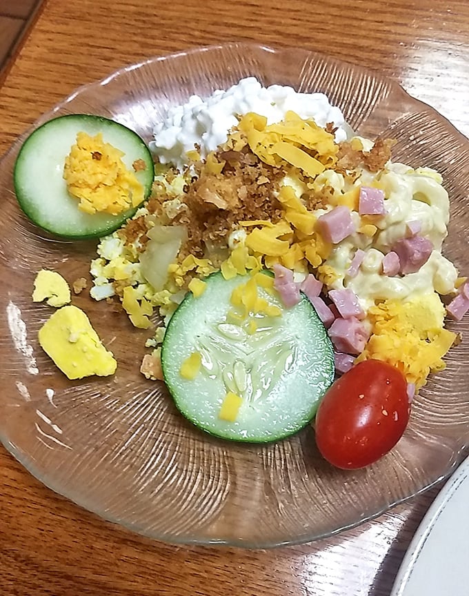 This isn't just a side salad; it's a colorful supporting actor in your meal's blockbuster production, complete with ham bits and cheese confetti.