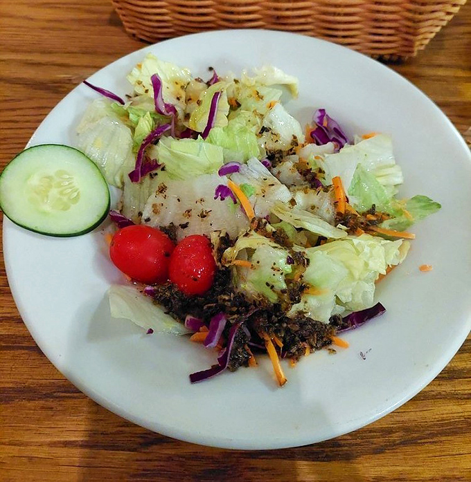 Even the salad shows personality with vibrant purple cabbage and cherry tomatoes. A refreshing counterpoint before the carnivorous indulgence begins.
