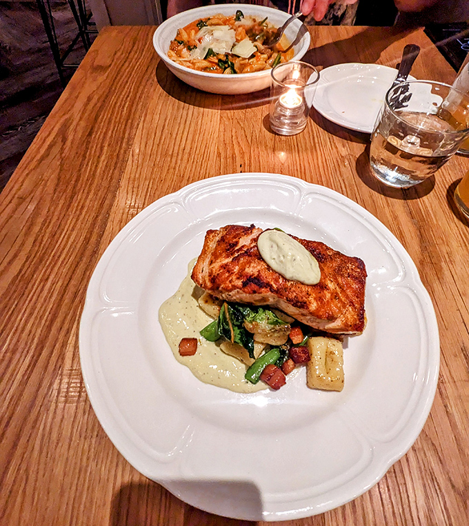 Salmon elevated to celebrity status—perfectly seared with seasonal vegetables in a presentation that's both rustic and refined.