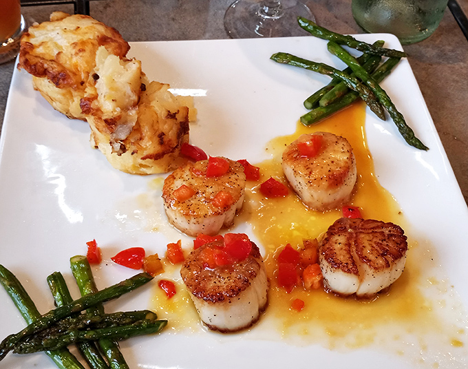 Perfectly seared scallops dance with asparagus in a buttery sauce – proof that seafood can find its perfect expression in landlocked Ohio.