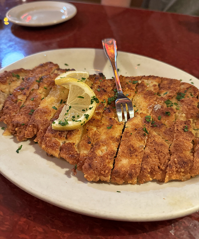 This schnitzel isn't just pounded thin&mdash;it's been persuaded into submission. Crispy, golden perfection with a squeeze of lemon that brightens every magnificent bite.