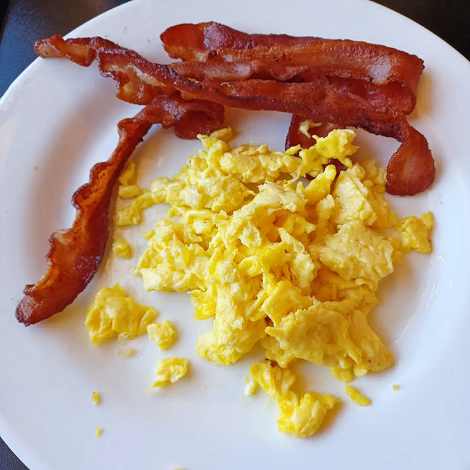 Breakfast fundamentals done right: scrambled eggs with the fluffiness of clouds and bacon cooked to that perfect crisp-but-not-burnt state.