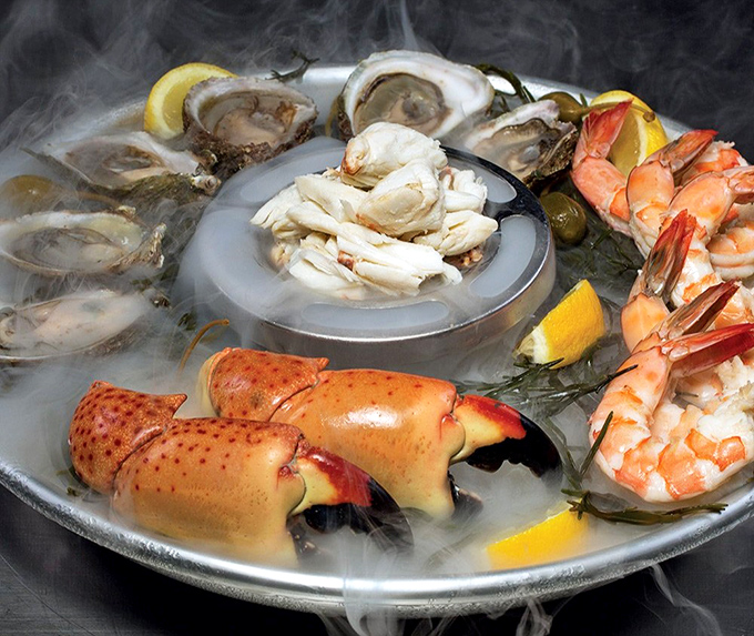 The seafood tower arrives in a dramatic fog, like your dinner is making its entrance on a Broadway stage.