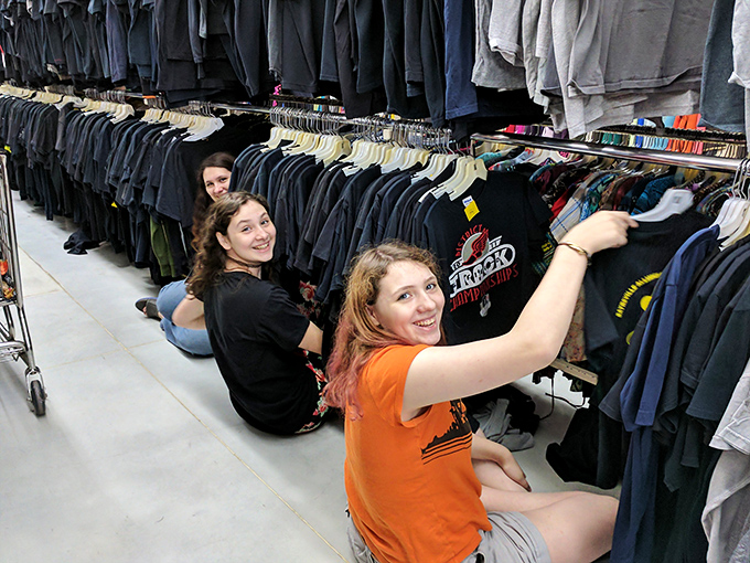 The true thrill of thrifting captured &ndash; shoppers diving deep into racks, experiencing that universal joy of discovering hidden gems among the hangers.