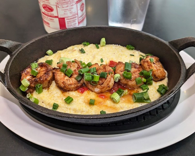 Blackened shrimp lounging on creamy grits like they're at a five-star resort &ndash; Florida's coastal bounty meets Southern comfort.