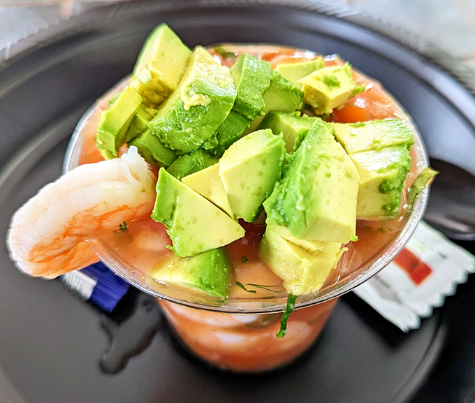 A seafood cocktail that's part meal, part vacation – chunks of shrimp swimming in tomato broth with avocado islands floating on top.