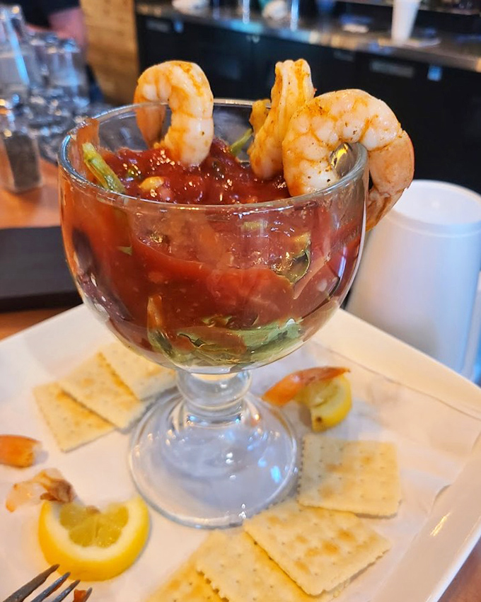 Shrimp cocktail that's dressed for success – plump crustaceans perched on the edge of a glass like they're about to dive into flavor town.