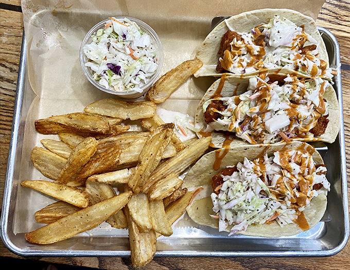 Tacos that make you question why you ever ate anything else. The slaw adds crunch, the sauce adds zing, and the fries are just showing off.
