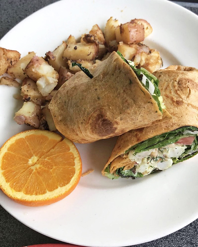 Breakfast goes worldly with this wrap stuffed with fresh greens and accompanied by perfectly roasted potatoes and a slice of sunshine.