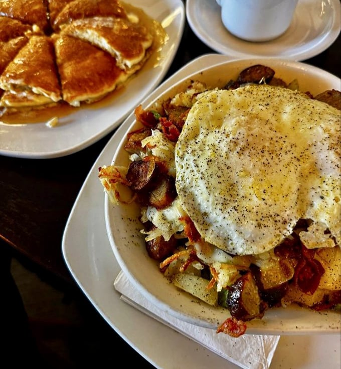 Breakfast potatoes topped with a sunny-side egg&mdash;proof that sometimes the simplest combinations create the most profound satisfaction. Pancakes lurk temptingly in the background.