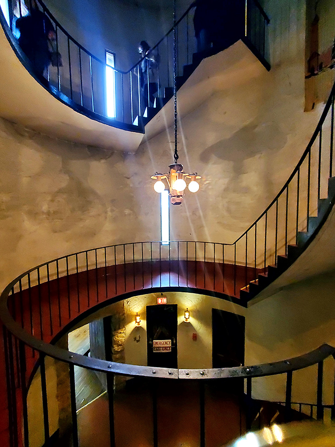 The castle's dramatic spiral staircase winds upward like a medieval DNA strand, connecting different eras through its wrought iron elegance.