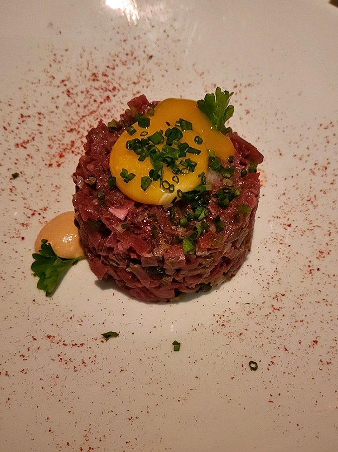 Steak tartare that's dressed better than most people at the restaurant. Raw beef elevated to art form with that perfect egg yolk crown.