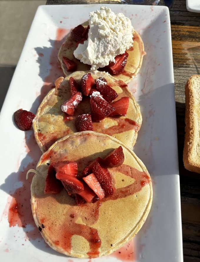 Strawberry shortcake gets the pancake treatment here, where fresh berries and cream transform breakfast into a justifiable dessert experience.