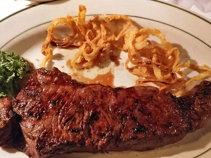 The strip steak glistens with juices, its perfect crust bearing the marks of a broiler that's seen decades of service to the cause of carnivorous joy.