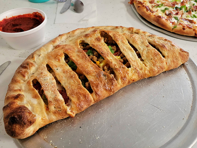 The stromboli arrives like an edible art piece&mdash;a golden-brown pastry revealing savory treasures with each steam-releasing cut.