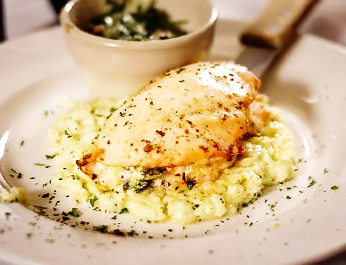 Tender chicken breast resting on cloud-like mashed potatoes. The kind of dish that makes you close your eyes with each bite.