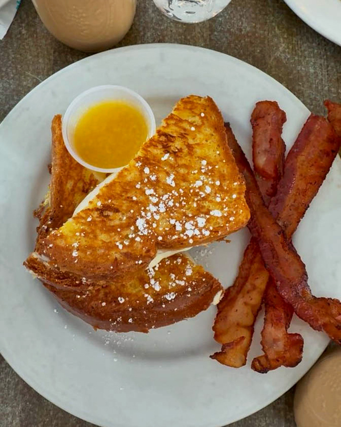 French toast that's dressed for success &ndash; crispy exterior, custardy interior, and bacon sidekicks that deserve their own spinoff show.