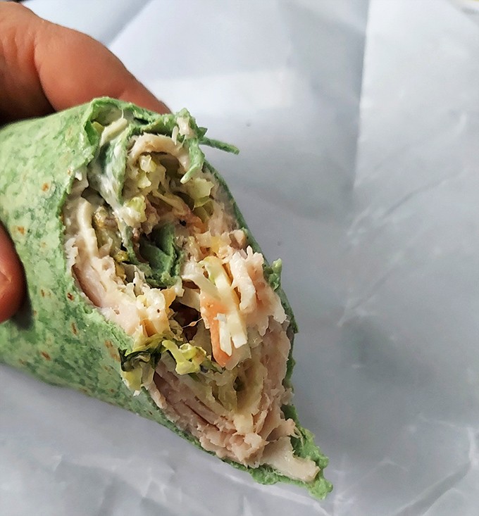 Even their wraps deserve attention! That vibrant green tortilla houses a carefully constructed world of flavors waiting to be discovered.