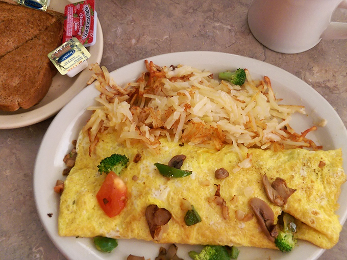 Breakfast artistry at its finest&mdash;a fluffy omelet stuffed with fresh vegetables and crowned with a snowfall of hash browns that puts ordinary morning meals to shame.