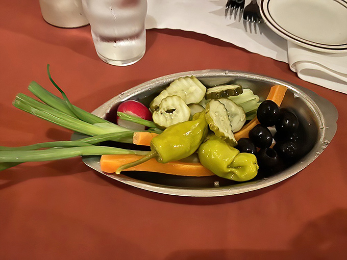 The relish tray—a vanishing tradition elsewhere—thrives here, offering crisp, colorful vegetables that provide the perfect counterpoint to the smoky richness of the grilled meats.