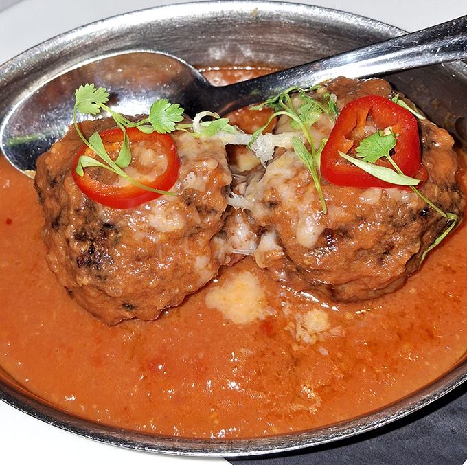 These meatballs don't just sit there looking pretty—they're Wagyu beef dressed for the prom in a tomato sauce tuxedo with herb corsages.
