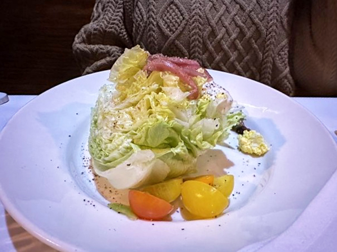 The wedge salad &ndash; that rare instance where iceberg lettuce gets to dress up fancy and remind everyone it still belongs at the grown-ups' table.