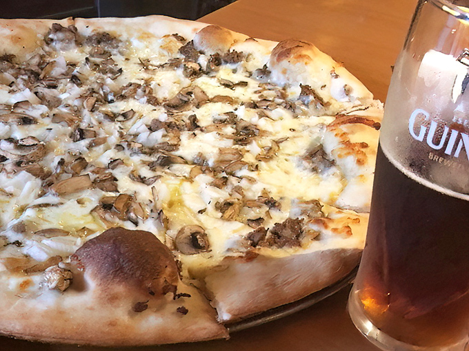 White pizza perfection paired with Guinness—a combination that proves soulmates exist in food form. Those mushrooms aren't just toppings; they're little umami bombs.