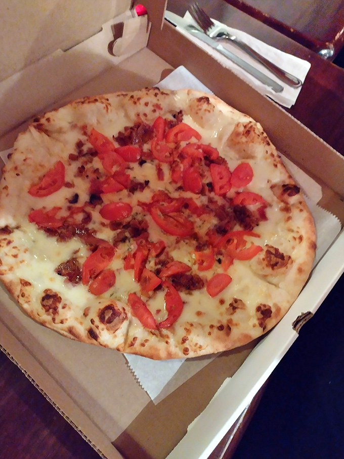 White pizza perfection in a takeout box, proving that sometimes the best meals travel well.
