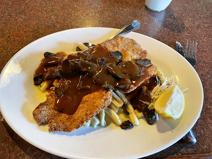 Wiener schnitzel smothered in mushroom gravy that would make your Austrian grandmother weep with joy, perched atop a bed of noodles.
