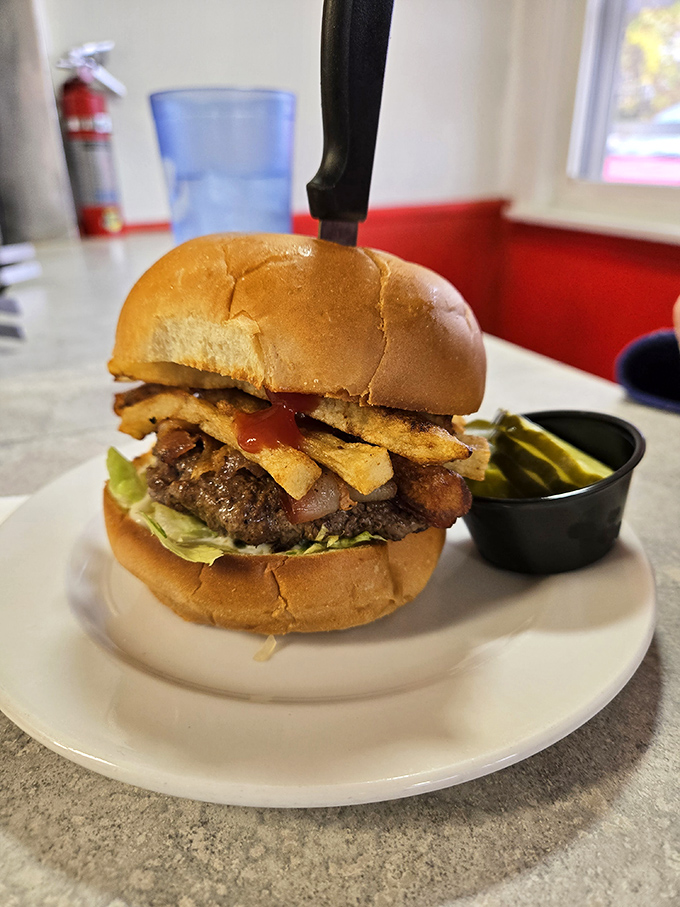 The burger arrives with fries standing at attention, as if they know they're in the presence of royalty on a humble white plate.