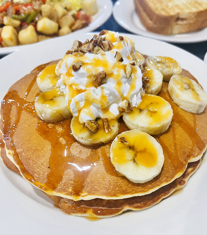 Pancakes topped with bananas, whipped cream, and nuts&mdash;because sometimes breakfast should feel like getting away with having dessert at 9 AM.