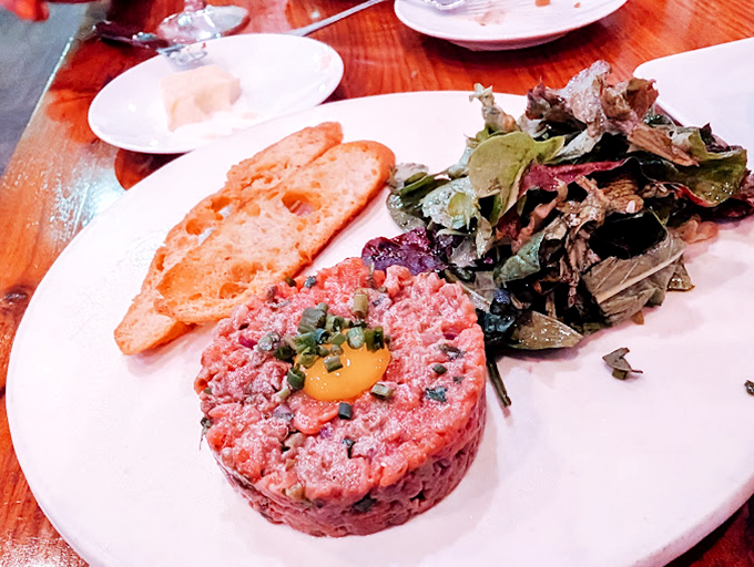 Beef tartare: where raw ambition meets exquisite execution. That sunny egg yolk crown is just waiting to anoint the perfectly seasoned meat below.