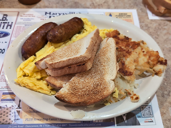 Breakfast of champions: eggs, sausage, toast, and hash browns arranged like a painter's palette of morning comfort.