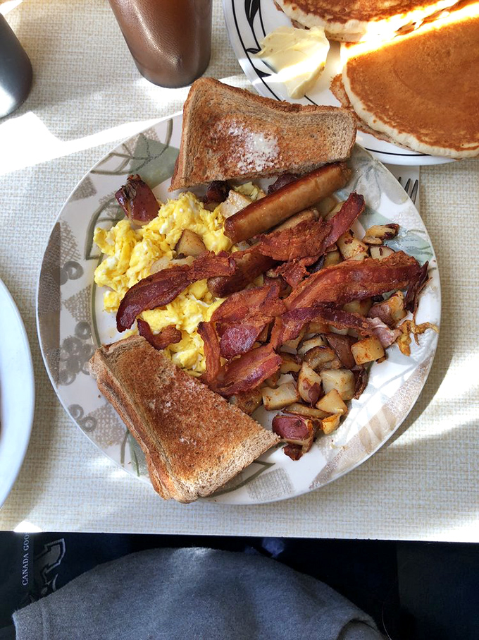 The classic breakfast platter: eggs, bacon, toast, and home fries arranged with the precision of a Renaissance painting, but infinitely more satisfying.