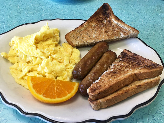 The breakfast trinity: perfectly scrambled eggs, sausage links with that satisfying snap, and toast waiting patiently for its butter bath.