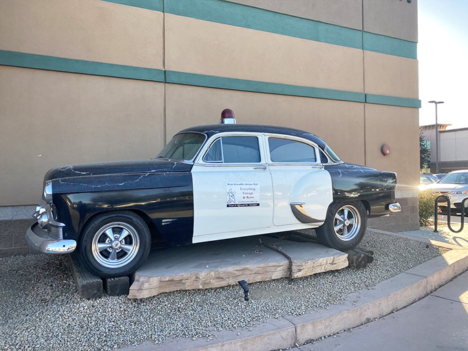 This vintage police cruiser stands eternal watch outside, a chrome-trimmed reminder of law enforcement from a bygone era.