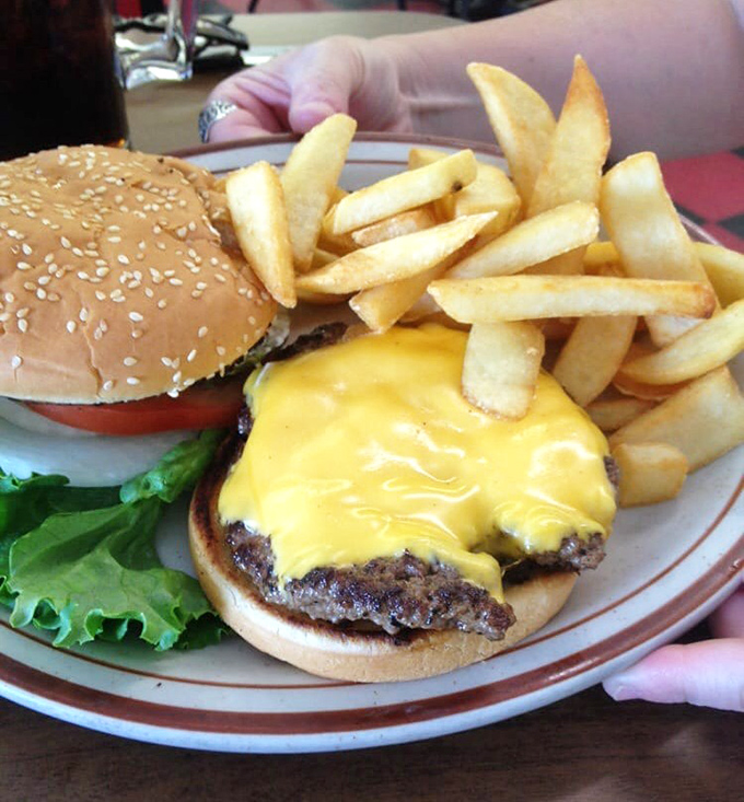 When lunch calls, this cheeseburger answers with melty American cheese cascading down the patty like a yellow waterfall of deliciousness.