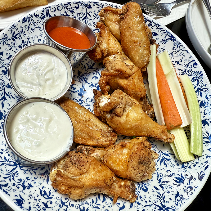 Wings that deserve their own fan club, served on a plate that's dressed better than most of us. The celery and carrots are just there to make you feel virtuous. 