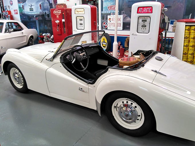 The Triumph's cockpit beckons adventure seekers, flanked by vintage pumps that once fueled America's love affair with the open road.