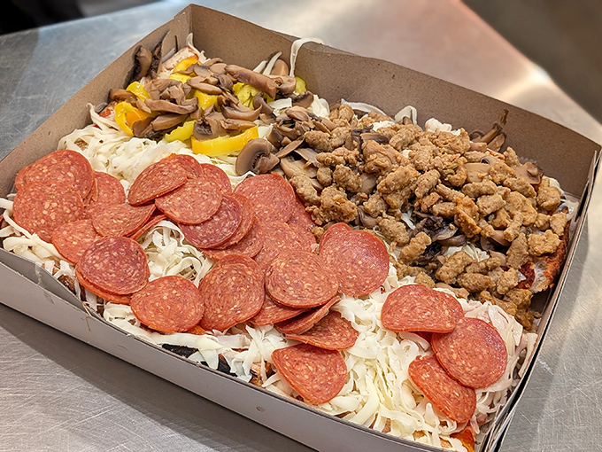 Pizza artistry in its final form &ndash; pepperoni, sausage, and mushrooms creating a topping trifecta atop that signature bed of unmelted cheese.