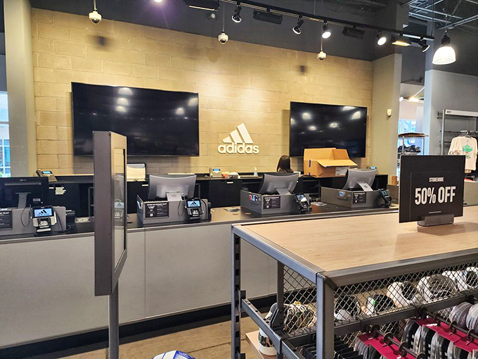 The Adidas outlet counter, where athletic aspirations meet affordable reality and 50% off signs work harder than your personal trainer.