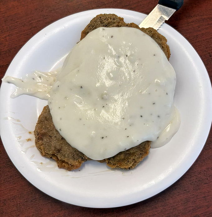 Country fried steak smothered in gravy—the kind of dish that makes you want to hug the cook and take a nap immediately after.