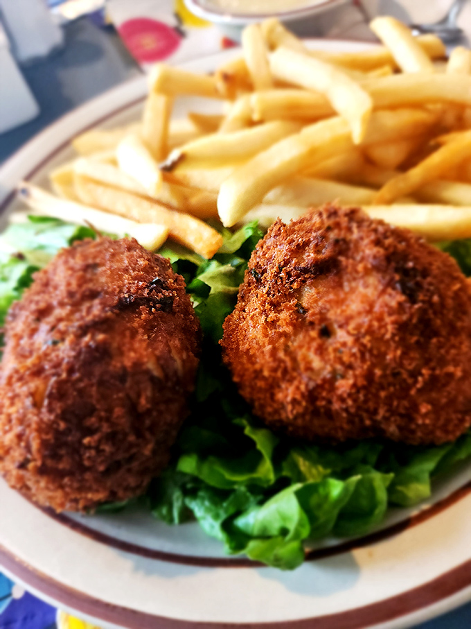 These crab cakes aren't just golden brown—they're Delaware gold. Minimal filler, maximum flavor, served on a bed of greens that knows its supporting role.