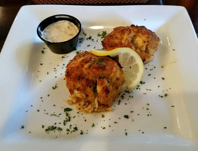 These golden beauties arrive looking like edible sunshine, making every other crab cake feel inadequate about their appearance.