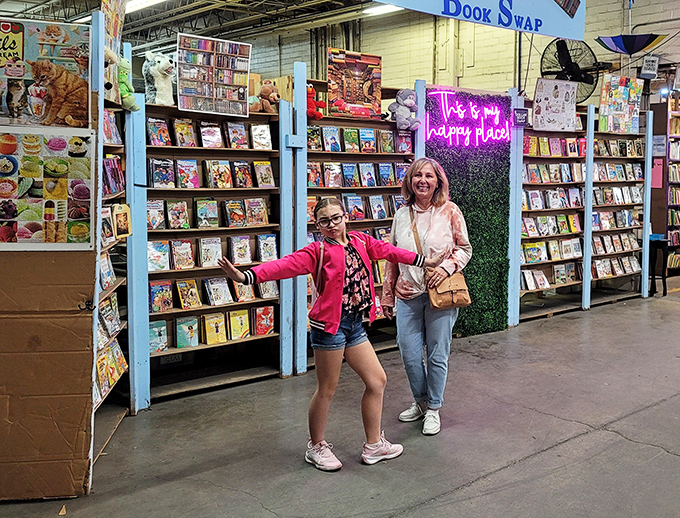 The universal expression of book-finding joy knows no age limit. That neon "happy place" sign in the background isn't just decoration&mdash;it's truth in advertising.