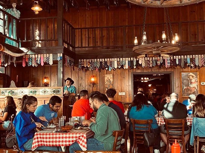 Beneath a ceiling adorned with surrendered neckties, diners dig into meals that would make John Wayne proud. No dress code, just good eating.