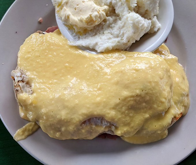 Hollandaise sauce blankets this Benedict like a golden sunrise, promising a morning of richness that's worth every calorie.